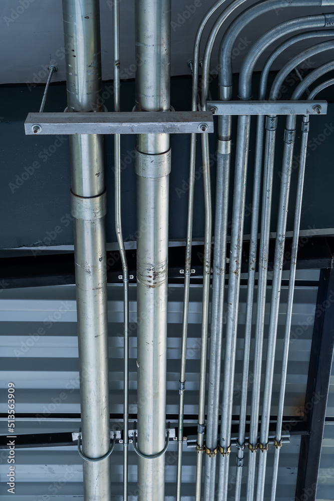 Metal power pipe on ceiling. Electrical conduits system, metal pipeline ...