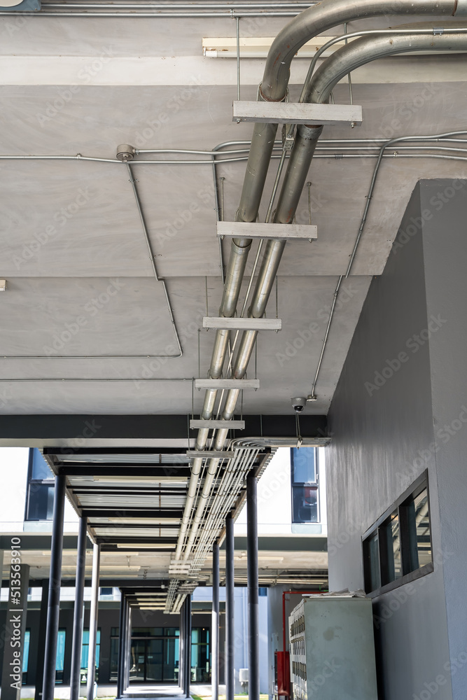 Metal power pipe on ceiling. Electrical conduits system, metal pipeline ...