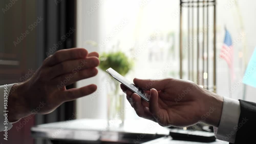 Male administrator giving tourist business man key card at hotel desk ...
