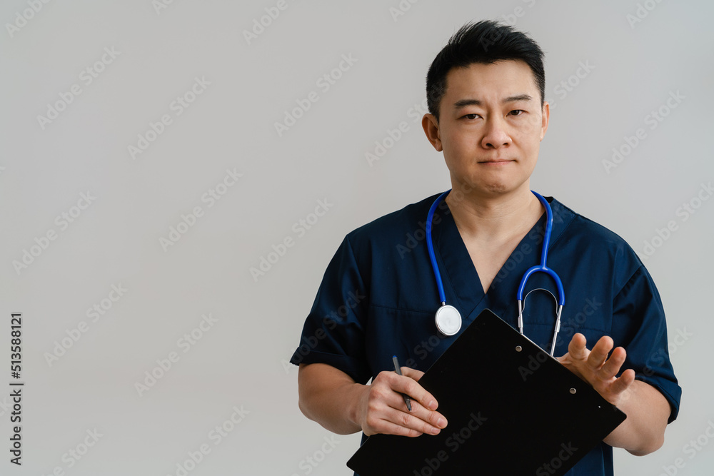 Adult man wearing medical uniform and stethoscope holding clipboard ...