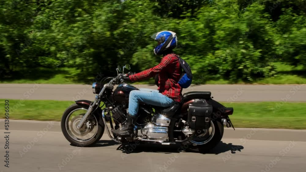 biker in red shirt and blue helmet in jeans drives his brown dragster ...