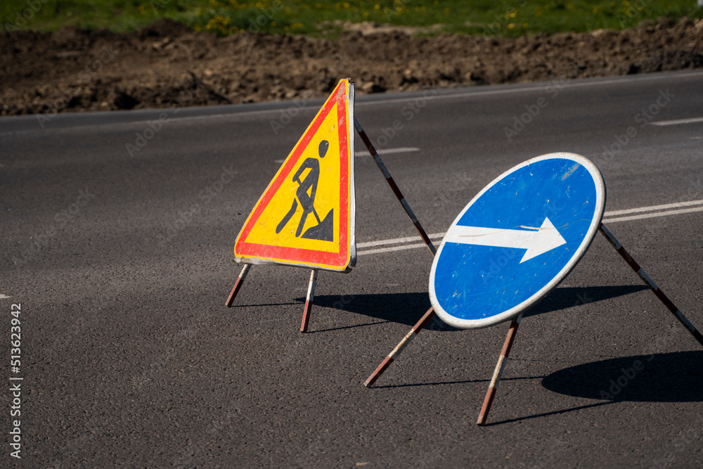 Road signs indicating the repair of asphalt and the direction to bypass ...