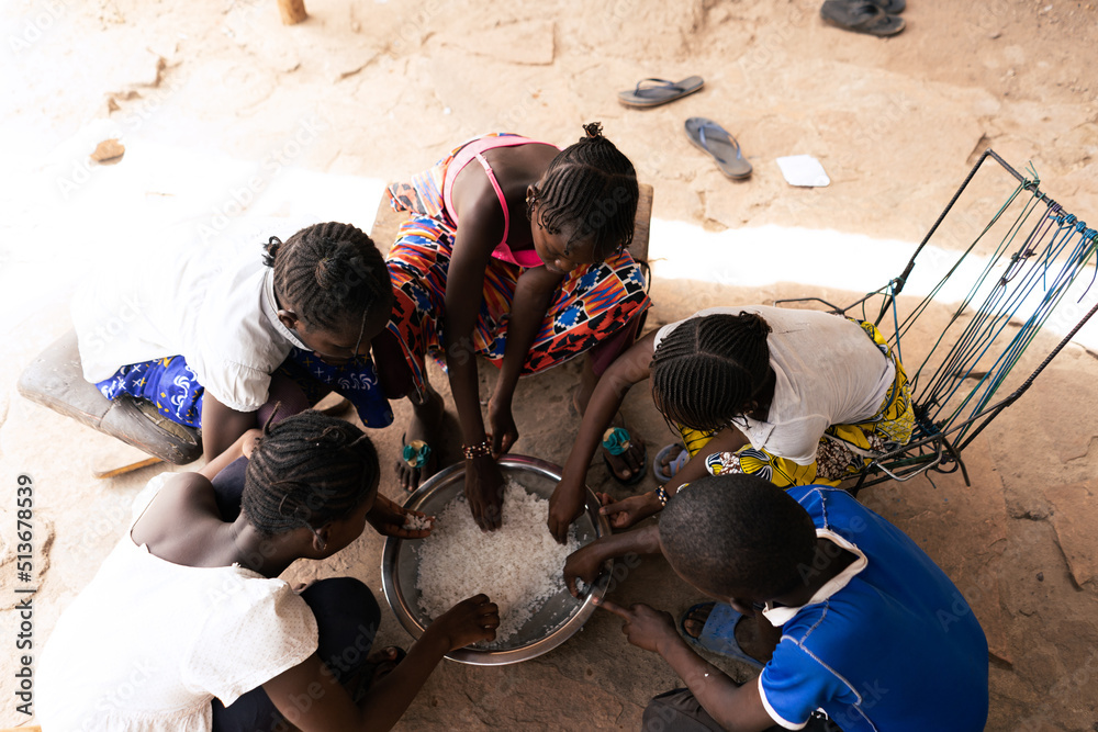 Overhead view of a group of African village children sharing a simple ...