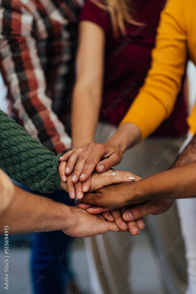 People standing in a circle and holding hands together, in the middle ...