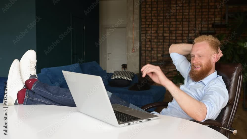 Remote work concept. Happy smiling redhead bearded man enjoys freelance ...