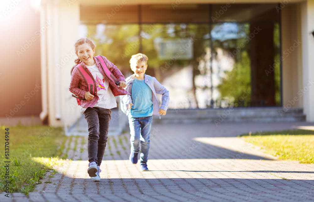 Girl and boy running from school after studying at it. Stock Photo ...