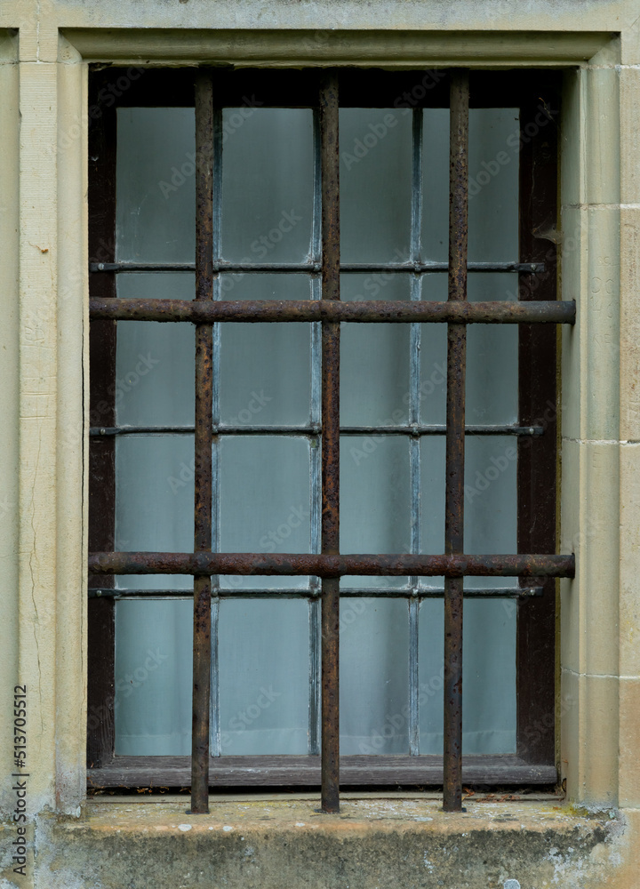 Barred window of a medieval building. Might be a prison or a bank vault ...