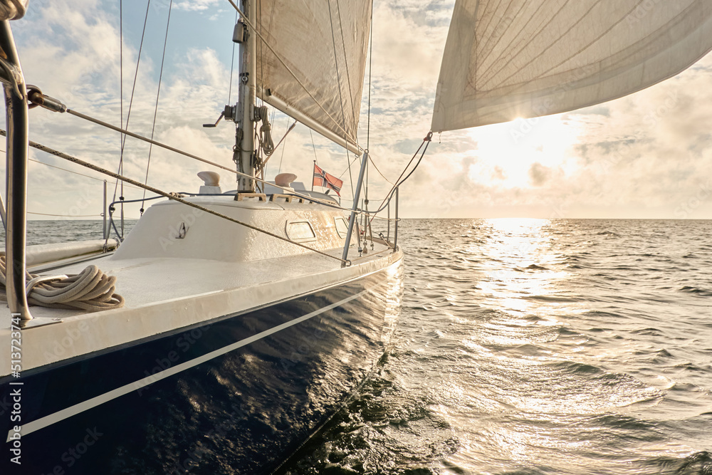 Yacht sailing in an open sea at sunset. Top down view of the deck, mast ...