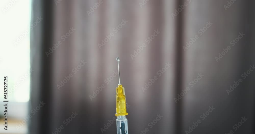 Thin insulin syringe, liquid comes out of needle, medicine. Drop falls ...
