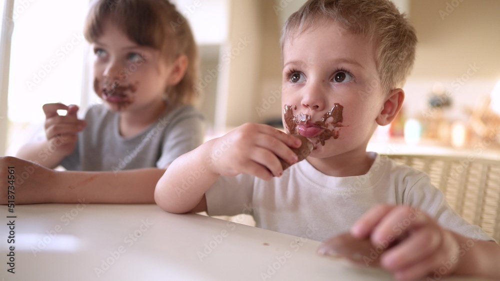 children eat chocolate. dirty little baby kids in the kitchen eating ...