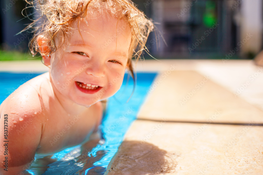 The baby is learning to swim. Family happiness. Little beautiful girl ...