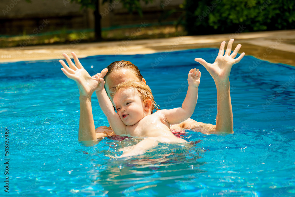 Mom and daughter in the pool. Happy child is having fun. A woman ...