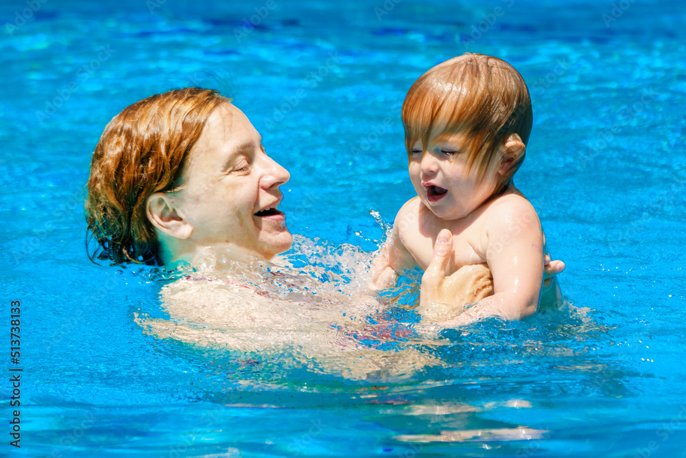 Mom and daughter in the pool. Happy child is having fun. A woman ...