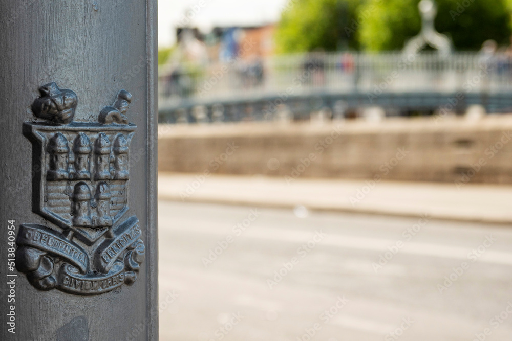 Coat of arms symbol of Dublin on a metal lamp post in focus. Ha'penny ...