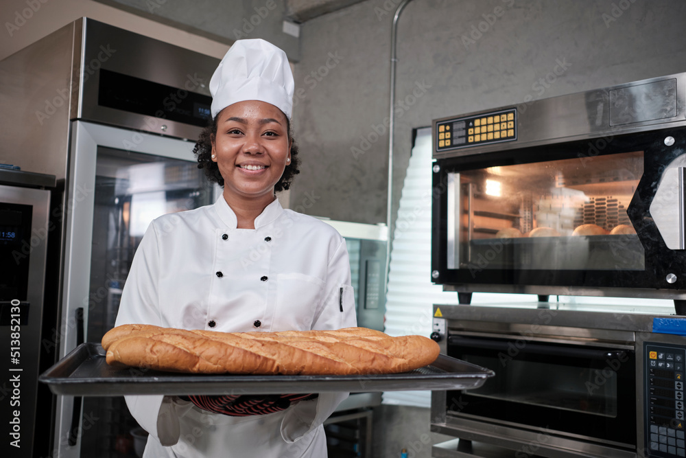 Portrait of African American female chef in white cooking uniform ...