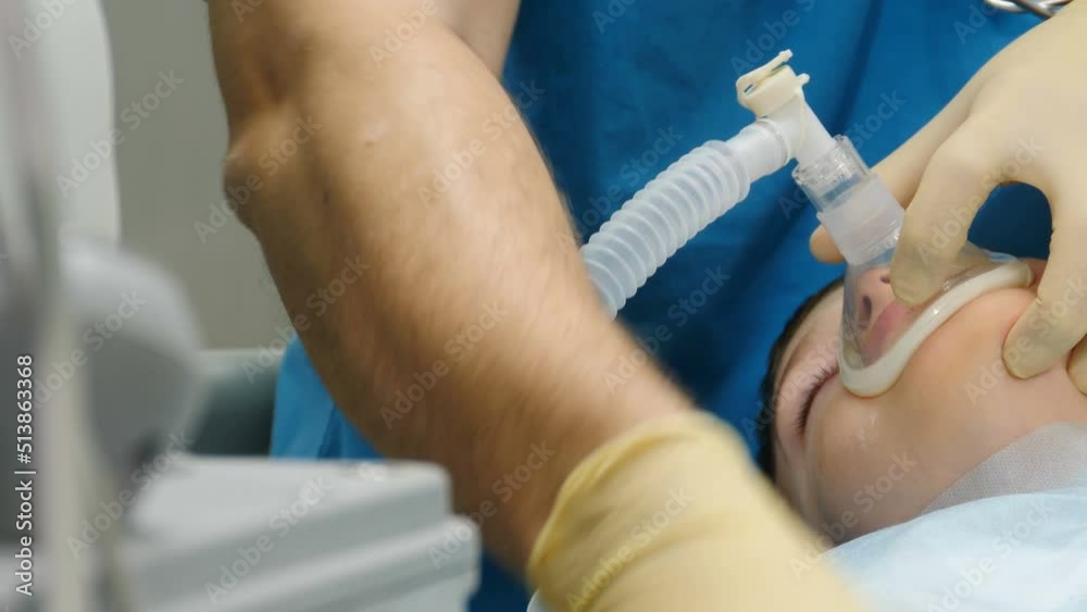 Little child under anaesthesia. Breathing mask on boy face. Health care ...