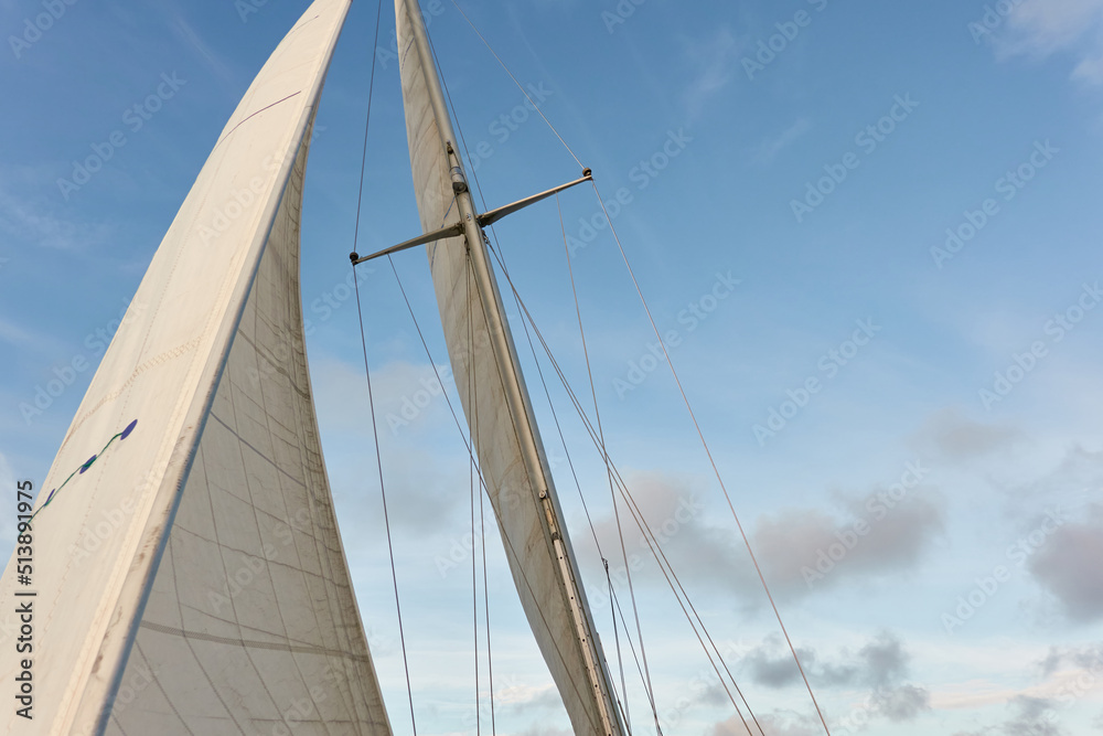 White sloop rigged yacht sailing in an open sea on a clear day. White ...