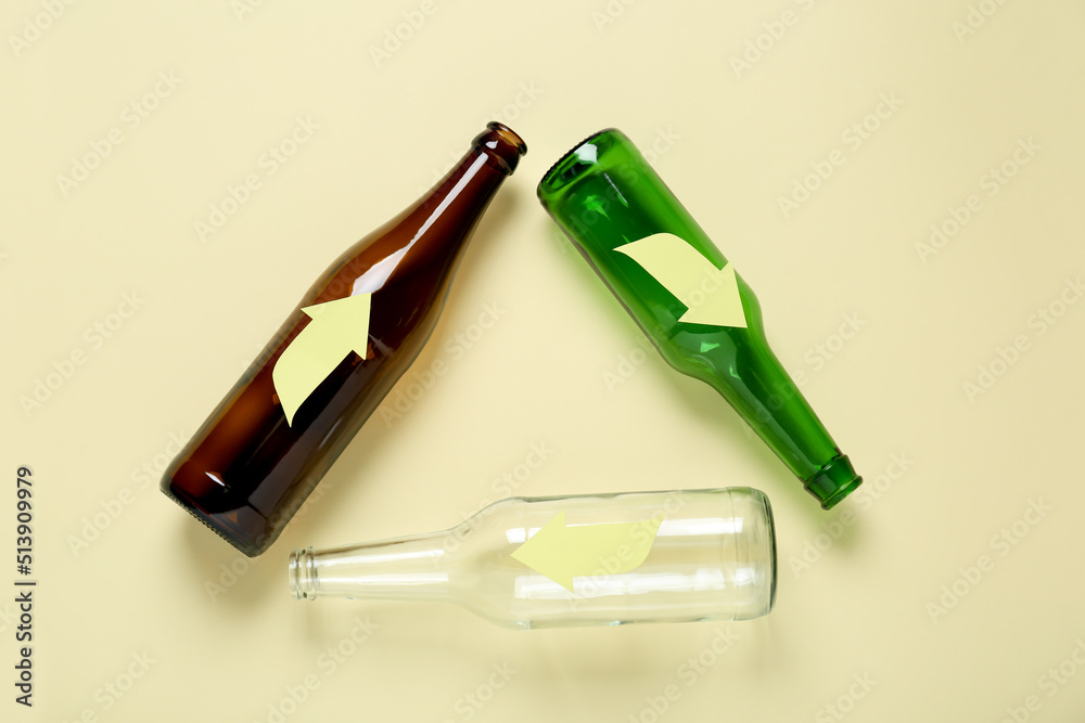 Recycling symbol made of empty glass bottles on beige background, flat ...
