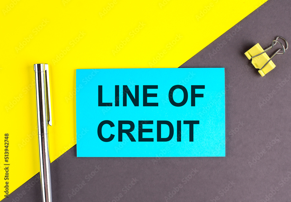 LINE OF CREDIT text written on sticky with pen on grey, yellow ...