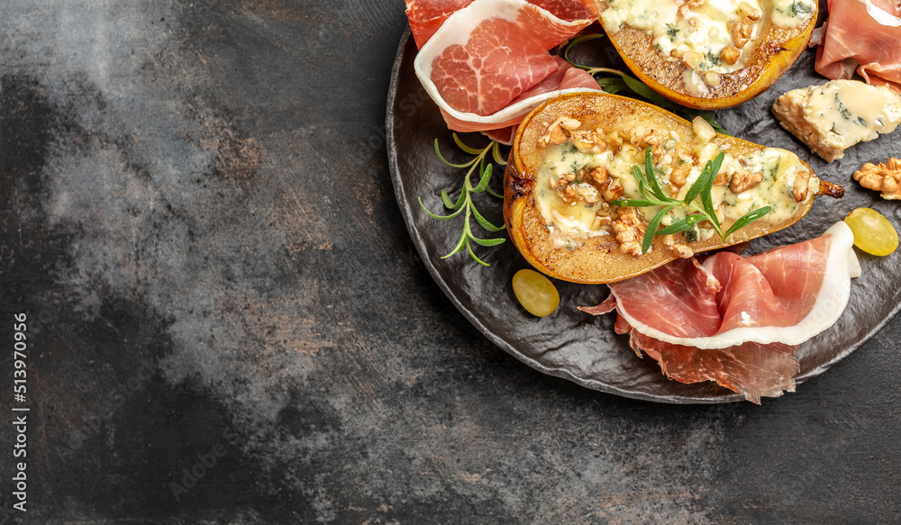 Appetizer with pear baked with blue cheese, nuts and honey, prosciutto ...