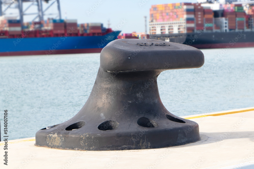 Sturdy metal mooring bollard at pier big black installed on concrete ...