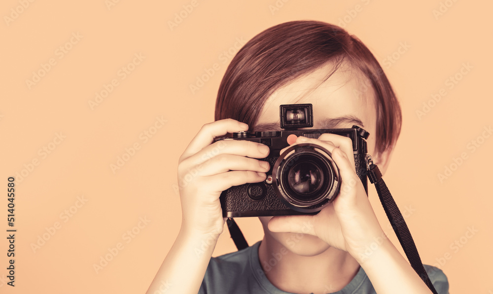 Little boy on a taking a photo using a vintage camera. Child in studio ...