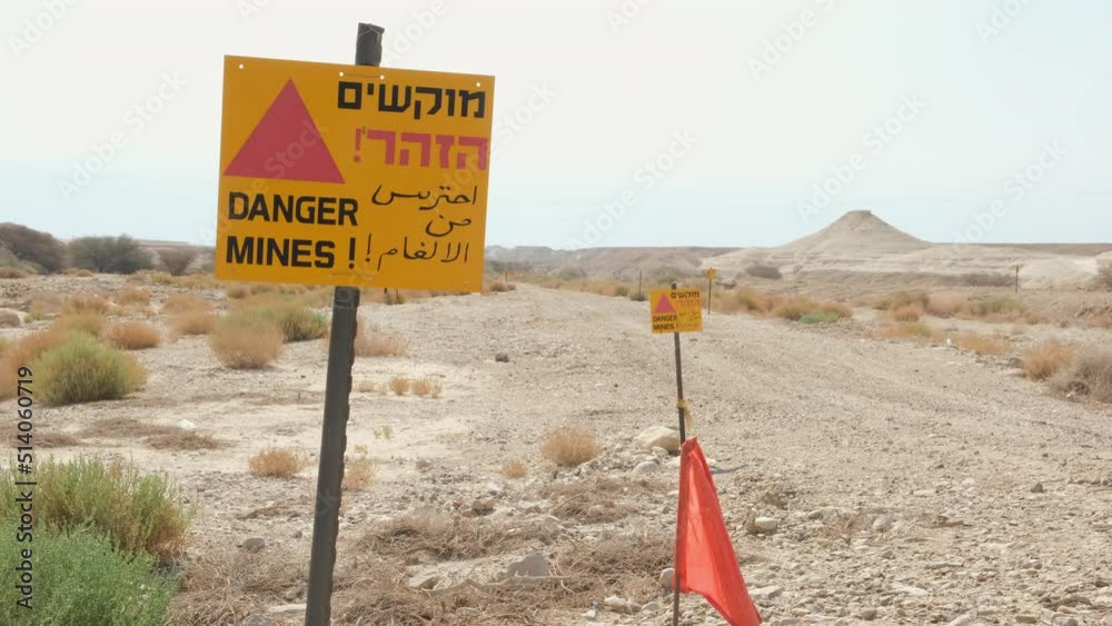 Sign with the text: Warning! Danger Mines in three languages on the ...