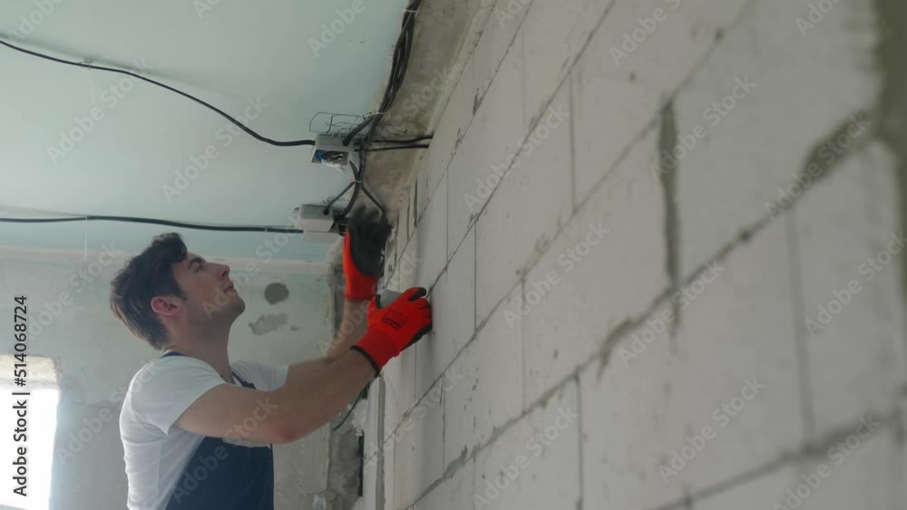 Electrician mounting junction box, instaling electrical wiring in ...