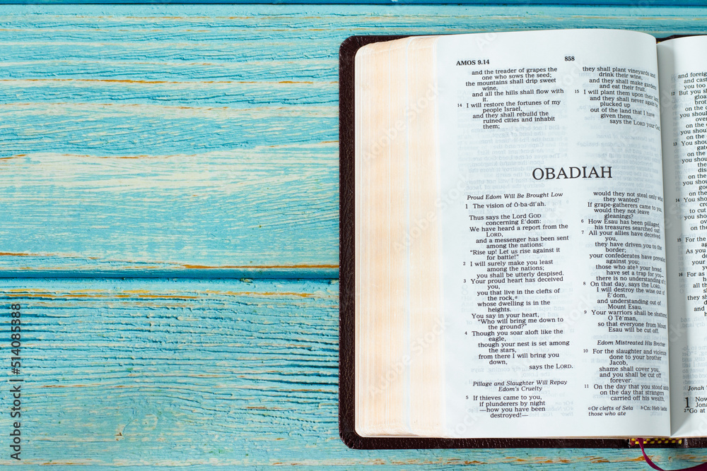 Obadiah open Holy Bible Book on a rustic wooden background with copy ...