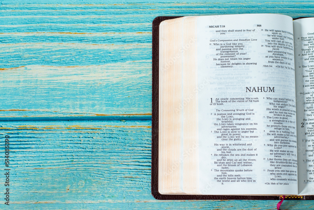Nahum open Holy Bible Book on a rustic wooden background with copy ...