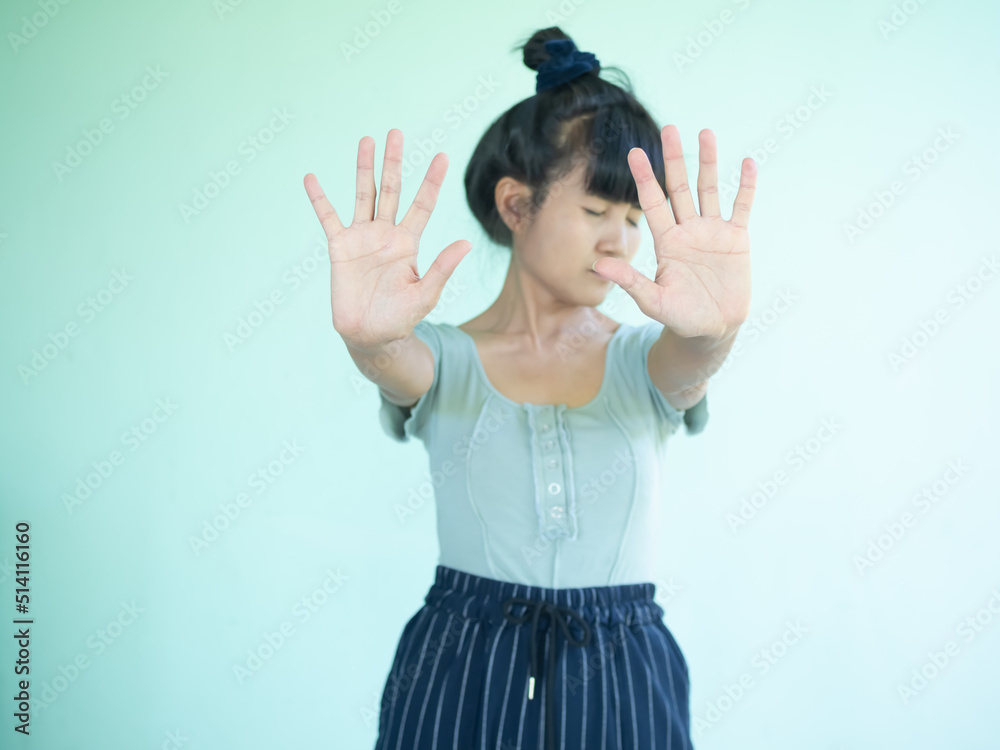Portrait alone woman showing finger no symbols on wall green cement ...