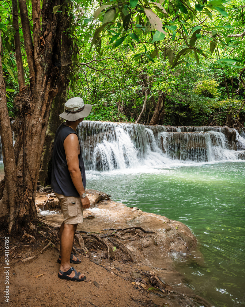 Thai guy Asian man backpacker men enjoying beautiful emerald waterfalls green forest mountains ...
