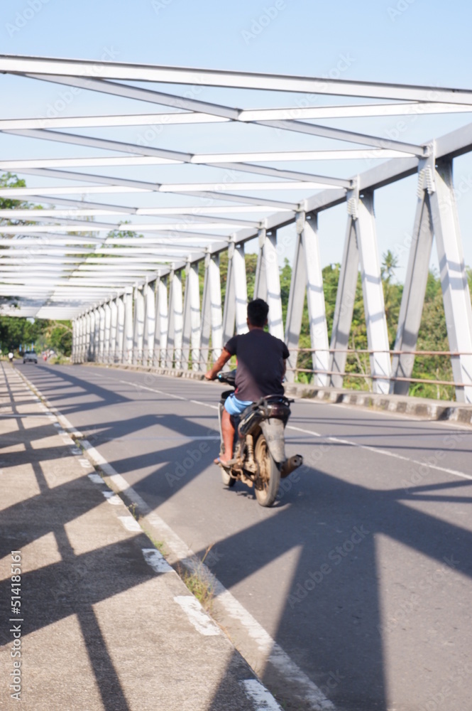 person riding a bike or iron bridge or jembatan konstruksi besi di kali ...