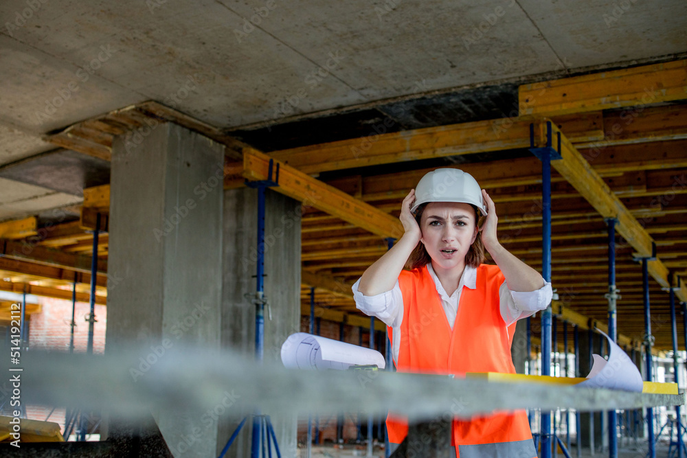 Foreman worker in a white protective helmet took hold of his head with his hands, because ...
