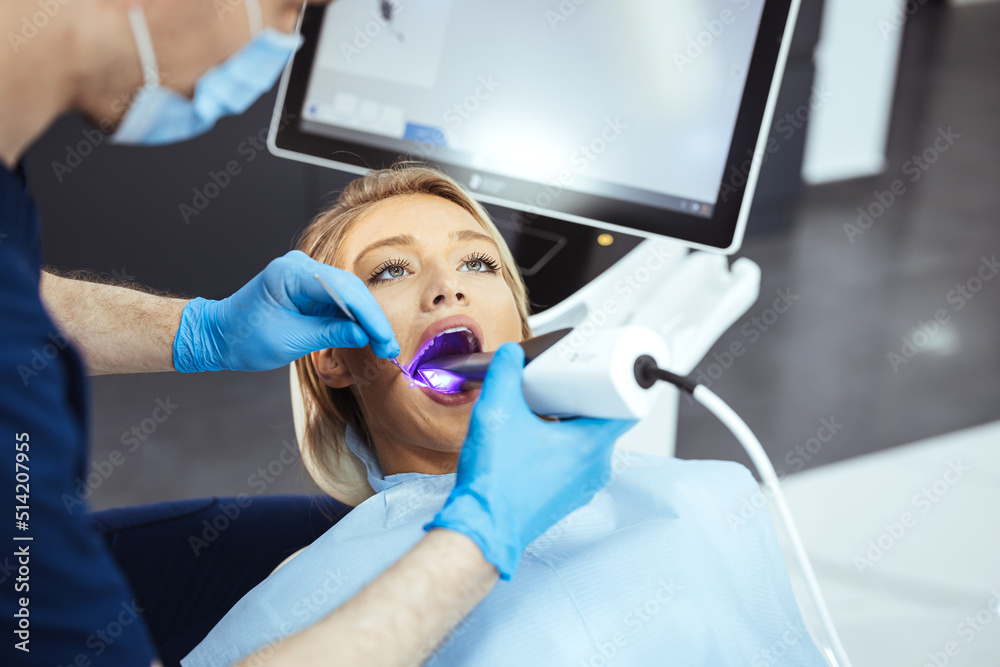 Dentist and patient in dentist office. Over the shoulder view of a ...
