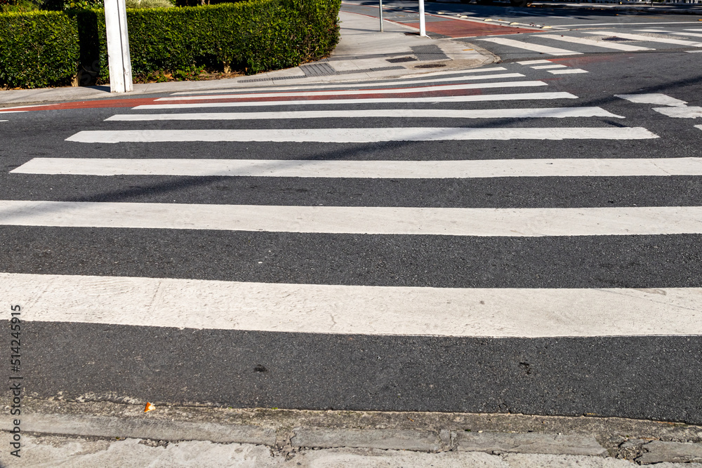 White lines on a city road at a pedestrian crossing. Asphalt and space ...