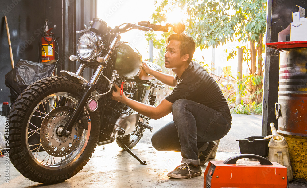 mechanic working on motorcycle at custom bike shop in Bangkok Stock ...