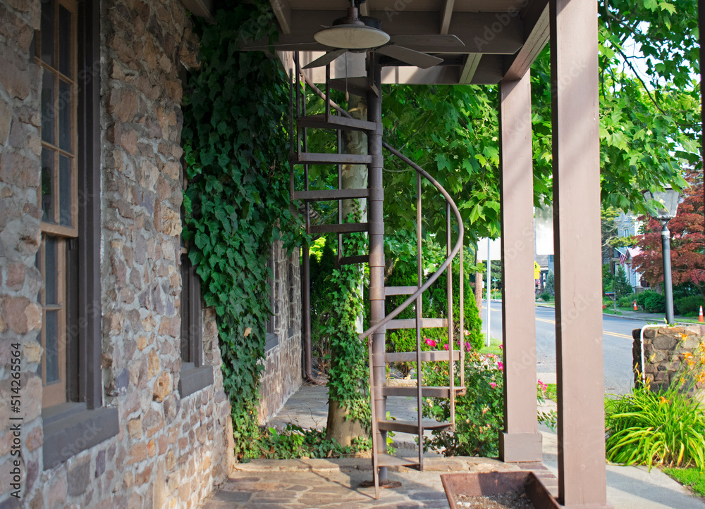 Looking through a portico at an outdoor spiral staircase next to a ...