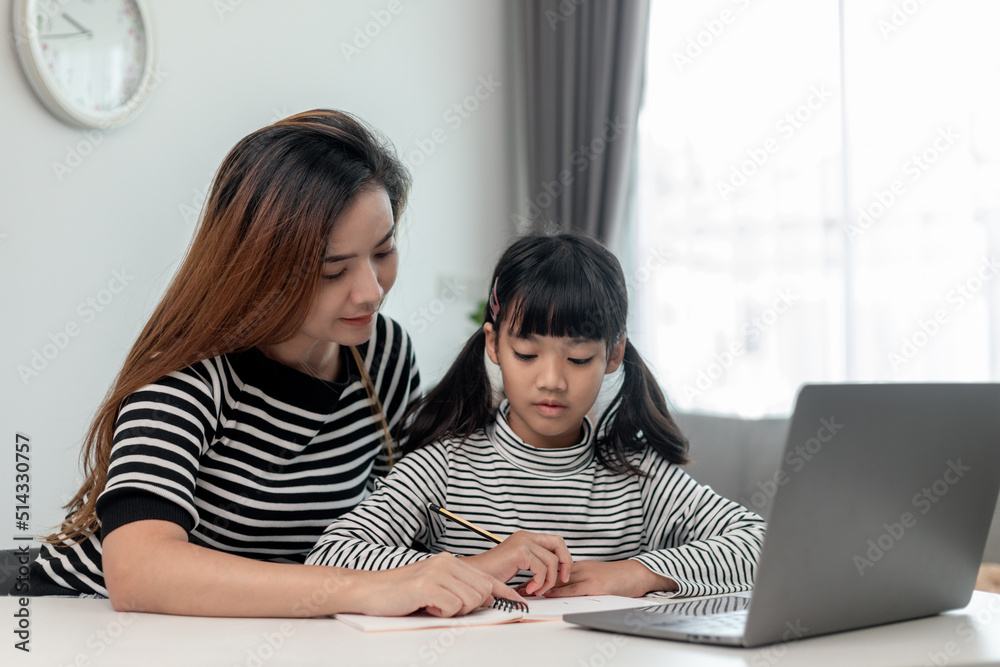 Asian little young girl kid learning online class at home with mother ...