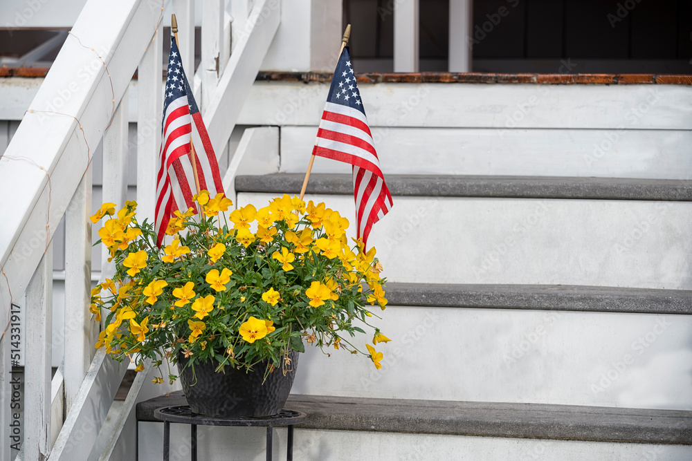 Flowers and US flags on the steps of the house. Vintage staircase at ...