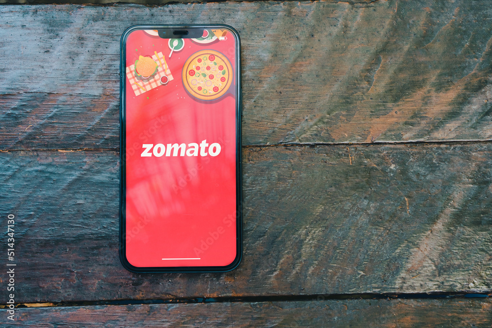 Zomato food delivery app on the smartphone screen on the rustic wooden ...