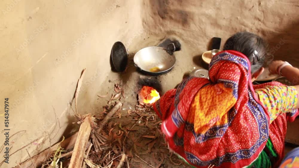 Traditional dressed Indian village woman cooking, Using traditional ...