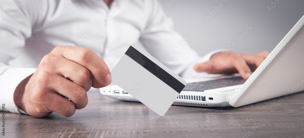 Businessman using laptop computer and holding credit card. Stock Photo ...