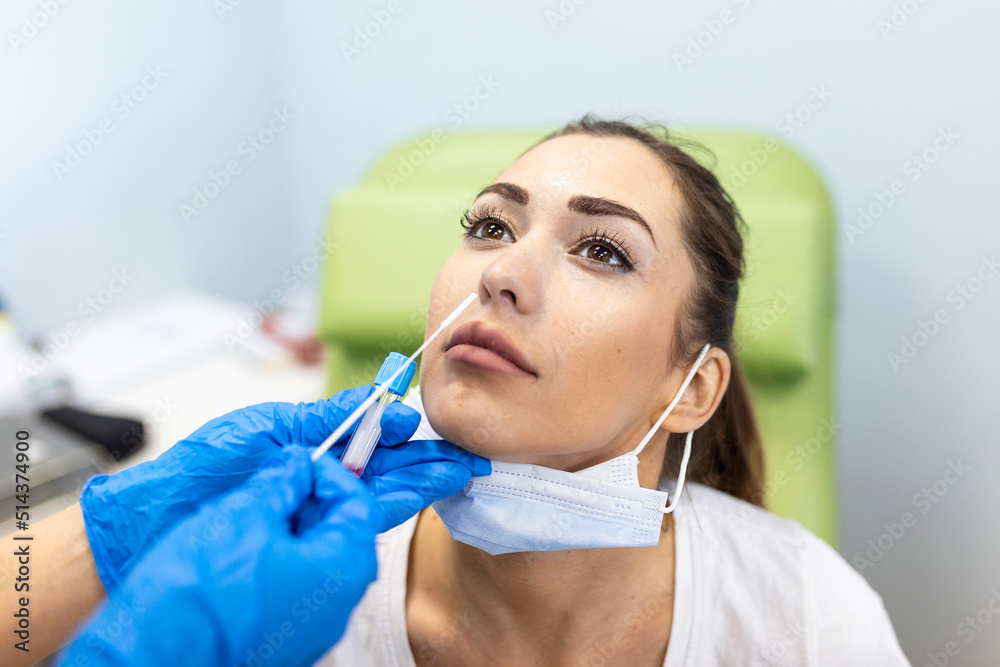 Female patient being tested for Covid-19 with a nasal swab, by a health ...