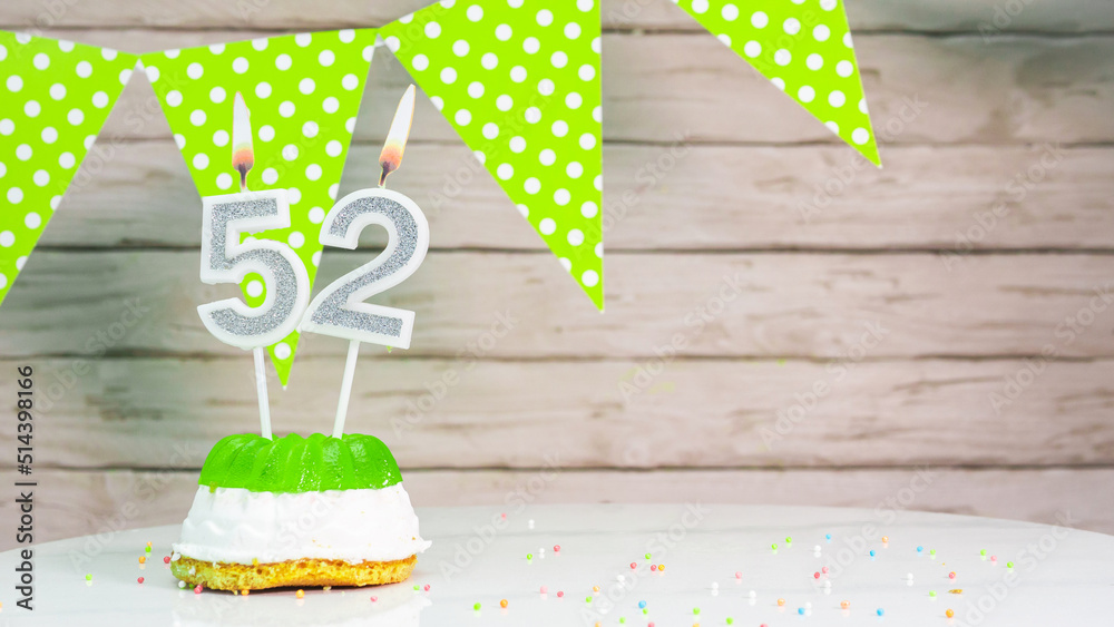 Beautiful festive background with the number 52 with a cake and lit ...
