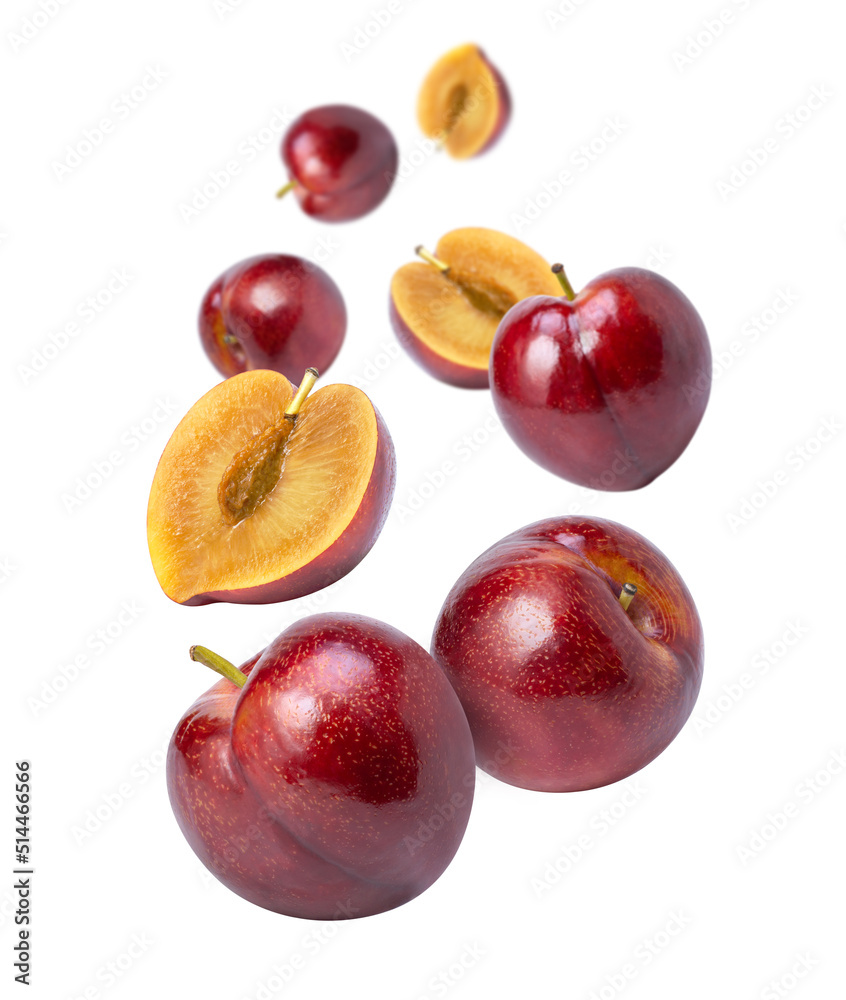 Red cherry plum fruit and cut in half sliced flying in the air isolated ...