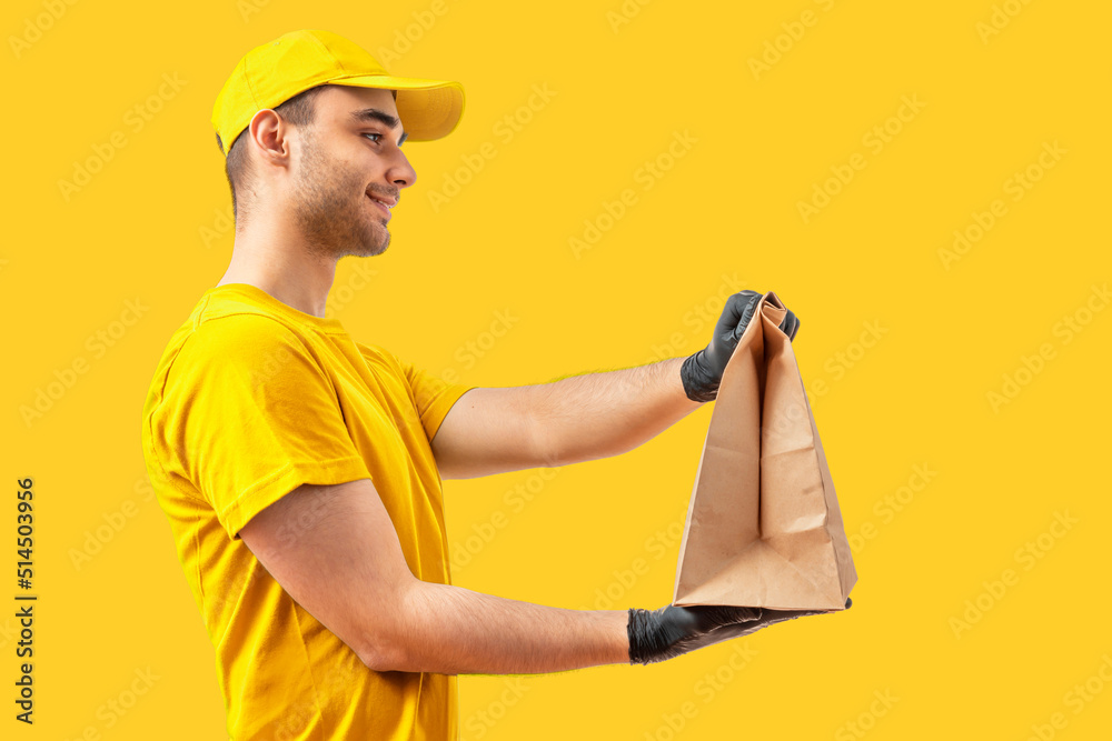 Delivery man with paper bag. Courier in uniform cap and t-shirt, gloves ...