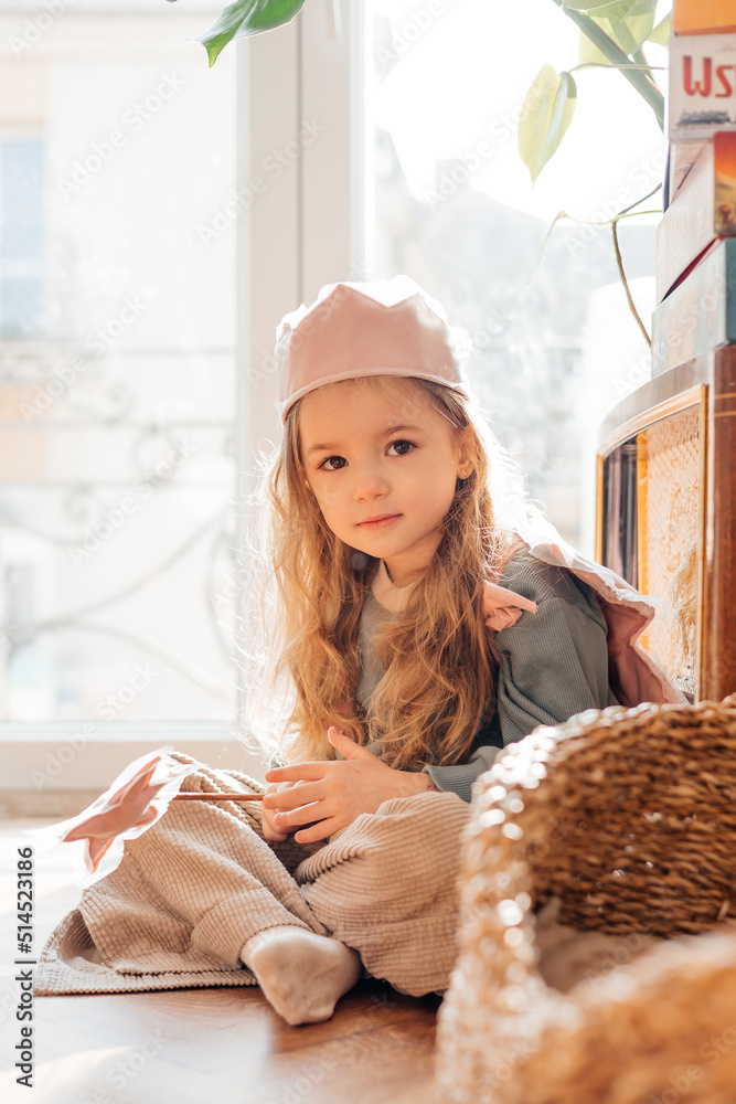 little girl wears pink wings, a crown, a magic wand and imagines ...