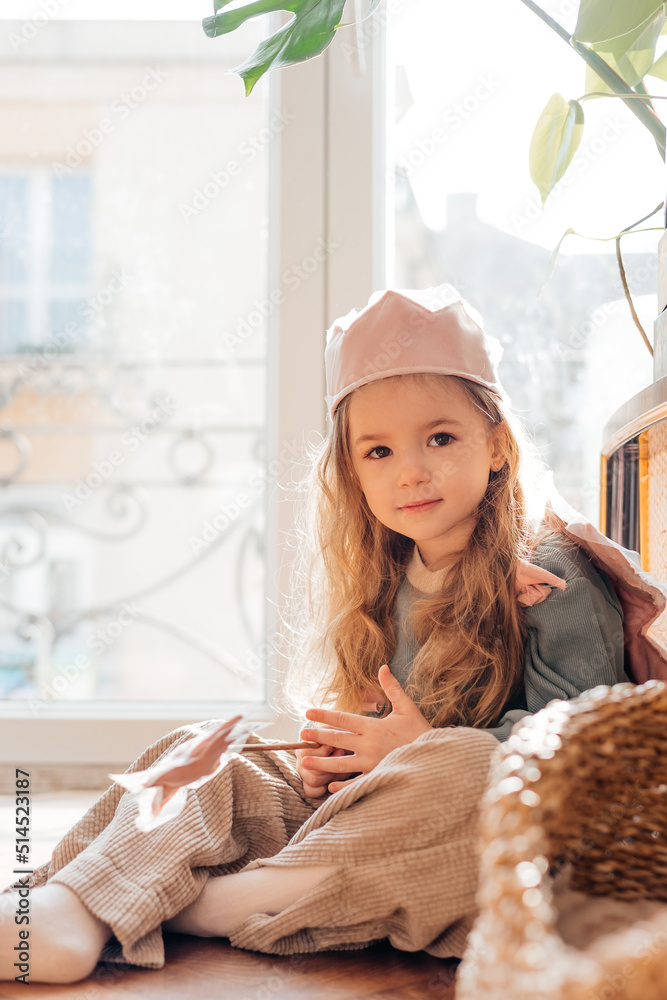 little girl wears pink wings, a crown, a magic wand and imagines ...