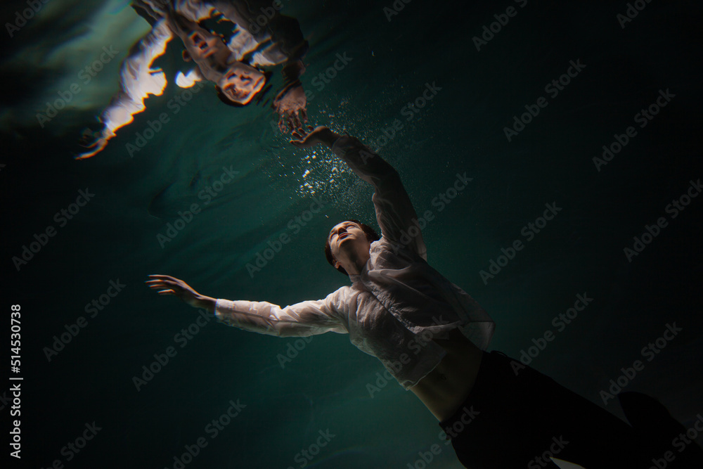 Beautiful underwater shooting, guy in white shirt and pants has fallen ...